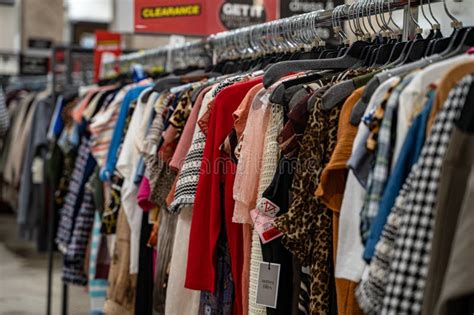 View Of Assorted Clothes On Hangers With Clearance Sale Signs In Retail