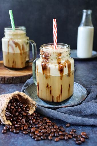 메이슨 항아리의 이미지 접시에 얼음과 우유와 혼합 차가운 검은 커피 회색 차 수건 우유 병 유출 커피 콩의 헤시안 자루 검은 배경 전경에 초점을 맞추고 유리 재료에 대한