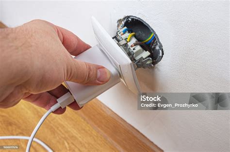 사람이 깨진 전원 콘센트에 꽂힌 흰색 Usb 휴대폰 충전기를 들고 있습니다 40 44세에 대한 스톡 사진 및 기타 이미지 40 44세 Diy Usb 케이블 Istock