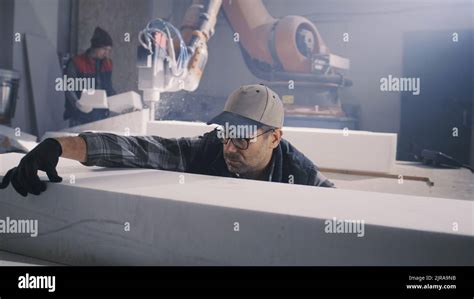 Middle Aged Male Employee In Cap And Glasses Examining And Putting