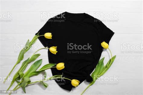 블랙 티셔츠 모형 템플릿 빈 셔츠 평면도입니다 흰색 나무 배경입니다 어머니 여성의 날 휴일입니다 노란 튤립 생일 꽃다발 꽃이 있는 여자 티셔츠 봄의 모습 여성 액세서리 0