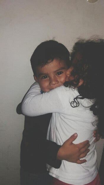 Premium Photo Portrait Brother Embracing Sister Against Wall At Home