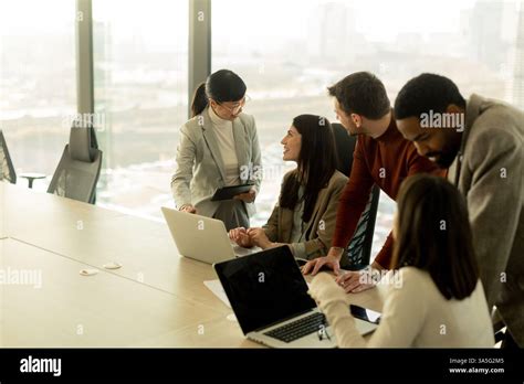 A Diverse Group Of Professionals Collaborates Around A Table In A Sleek