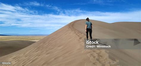그레이트 샌드 듄스 국립공원의 아름다운 사막 풍경에 있는 모래 언덕 꼭대기에 서 있는 사람 경관에 대한 스톡 사진 및 기타