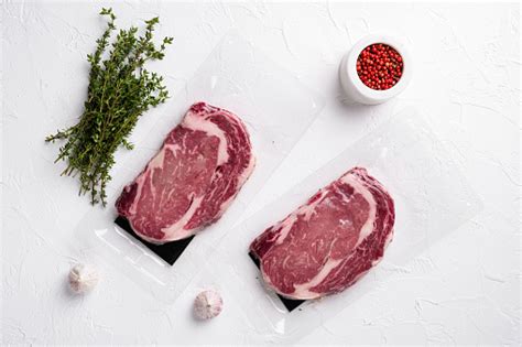 신선한 쇠고기 스테이크와 진공 플라스틱 팩 흰색 돌 테이블 배경에 상단 보기 플랫 레이 Entrecôte에 대한 스톡 사진 및 기타 이미지 Entrecôte 가방