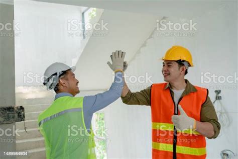 다민족 엔지니어가 서류 작업 및 평면도 도면 계약 및 계약 개념에 대한 비용 추정을 위해 거래 및 측정에 대해 브레인스토밍합니다