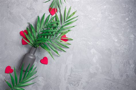 병에 녹색 잎꽃다발이 있습니다 하트 형태의 빨간색 모양은 회색 콘크리트 배경에 있습니다 발렌타인 데이 어머니의 날을위한 레이아웃 플랫 레이 맨 위 보기입니다 공간을