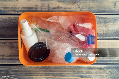 나무 배경에 플라스틱 항아리 모자 펠리클 및 컵 쓰레기로 가득 찬 주황색 플라스틱 용기 상자 온실 효과 0에 대한 스톡 사진 및 기타 이미지 Istock