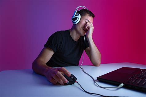 네온 불빛이 켜진 어두운 방에서 컴퓨터에서 비디오 게임을하는 헤드폰을 착용한 게이머 Brand Name Video Game에 대한 스톡 사진 및 기타 이미지 Brand