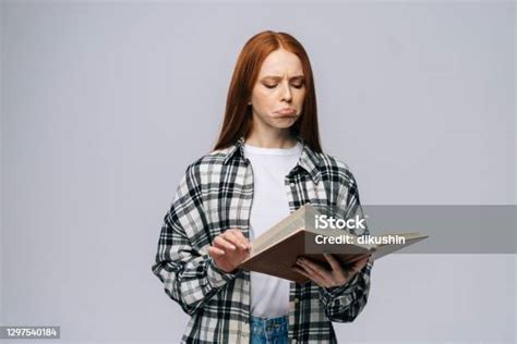 혼란 스러운 젊은 여자 대학생 회색 고립 된 배경에 책의 페이지를 선회 공부에 대한 스톡 사진 및 기타 이미지 공부 교습