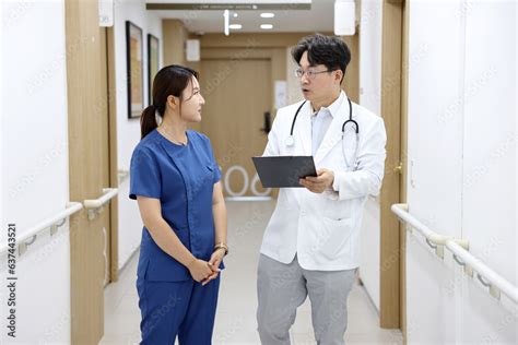 병원 복도에서 의사와 간호사가 걸어가면서 회의하고 지시를 하는 모습 Foto De Stock Adobe Stock