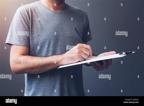Casual Adult Male Writing Notes On Notepad Paper Unrecognizable Guy In Gray T Shirt With Pencil