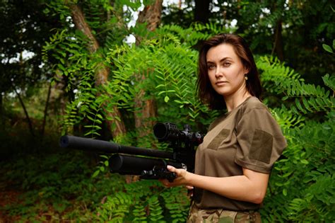빽빽한 푸른 숲 속에 한 여성이 조준경이 달린 저격용 소총을 움켜쥔 채 당당하게 서 있습니다 30 34세에 대한 스톡 사진 및 기타 이미지 Istock
