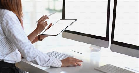 두 사업가의 자른 샷은 현대 사무실에서 디지털 태블릿과 다중 화면 컴퓨터로 프로젝트를 컨설팅하고 있습니다 사진 Unsplash의 사업 이미지