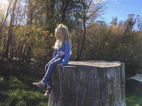 Premium Photo Girl Sitting On Tree Stump In Forest