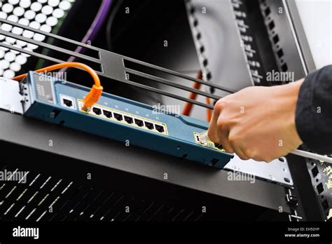 IT Consultant Inserting Connecting A Network Cable Into A Switch Stock Photo Alamy