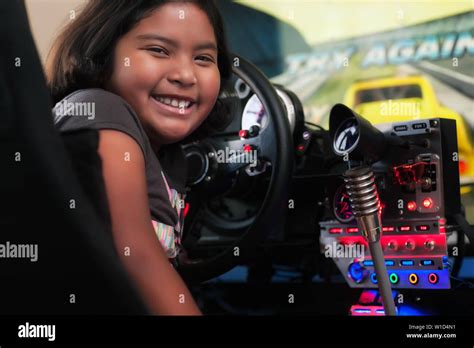 A Cute Girl With A Big Smile Playing A Driving Game In A Realistic