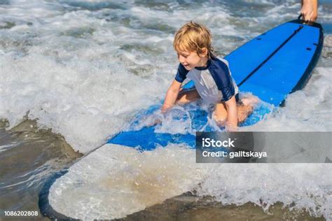해피 아기젊은 서퍼 바다 파도에 재미 있는 서핑 보드에 타고 활동적인 가족 생활 아이 야외 물 스포츠 레슨 및 서핑 캠프에서