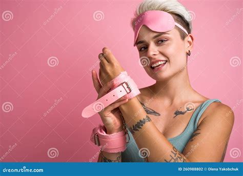 Tattooed Blonde Woman Wearing Bdsm Handcuffs Smiling Playfully To The