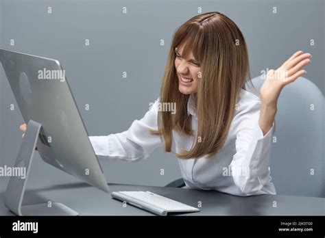 Angry Evil Pretty Blonde Businesswoman Worker Screaming To Desktop Raging After Computer