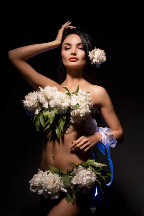 Sensual Naked Lady With White Flowers On Body Standing In Dark Studio