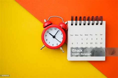 빨간색 아날로그 알람 시계와 흰색은 두 톤 노란색과 주황색 종이 배경 상단 보기에 흰색 열린 달력 개념에 대한 스톡 사진 및 기타 이미지 Istock