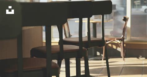 어두운 상점의 바 카운터 측면에 놓인 회색 바 의자의 실루엣 사진 사진 Unsplash의 무료 스타벅스 이미지