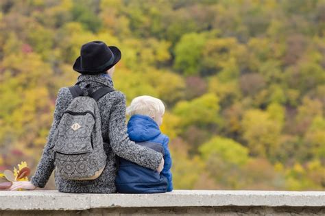 Premium Photo Mother And Son Are Sitting On A High Ground
