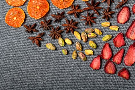 말린 귤과 딸기를 조각으로 잘라 디저트를 장식 합니다 근처에는 피스타치오와 아니 스가 있습니다 회색 배경에 있습니다 0명에 대한 스톡 사진 및 기타 이미지 Istock