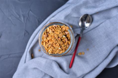 견과류 딸기 초콜릿을 어두운 콘크리트 배경에 유리 항아리에 곁들인 바삭바삭한 꿀 수제 그래놀라 아침 식사에 건강한 비건 간식 아이디어 맨 위 보기입니다 레시피 영양을 쉽게