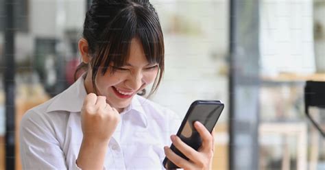 스마트 폰에서 좋은 소식을 읽고 성취를 축하하는 행복한 사업가 사진 Unsplash의 사무실 이미지