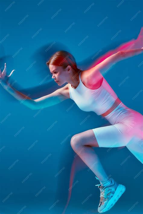 Premium Photo Running Female Athlete On Blue Backdrop Long Exposure Motion Blur Sports Girl