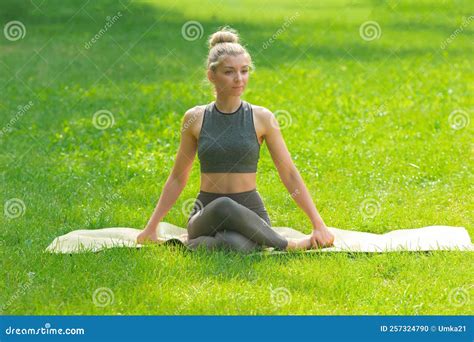Uma Mulher Magra Sentada Na Relva Verde Do Parque A Fazer Torres
