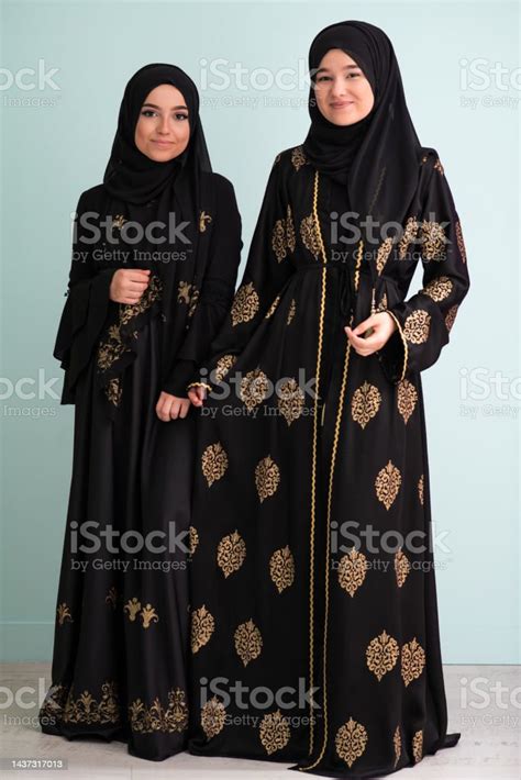 현대 이슬람과 라마단 카림의 개념을 나타내는 현대 청록색 배경에 고립된 히잡을 쓴 멋진 드레스를 입은 두 명의 아름다운 무슬림 여성 18 19세에 대한 스톡 사진 및 기타