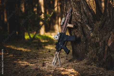 Assault Rifle Leaning On A Tree In The Forest Stock Photo Adobe Stock