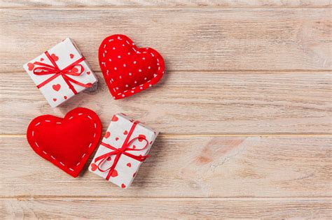 발렌타인 데이 또는 다른 휴일 수 제 종이에으로 현재 휴가 래퍼에 빨간 하트와 선물 상자 디자인을 위한 오렌지 나무 테이블 복사 공간 평면도 빈 공간에 선물 상자를 제시