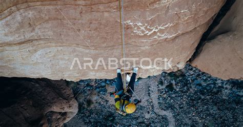 رجل يتسلق جبال مدينه العلا في المملكة العربية السعودية التكوينات