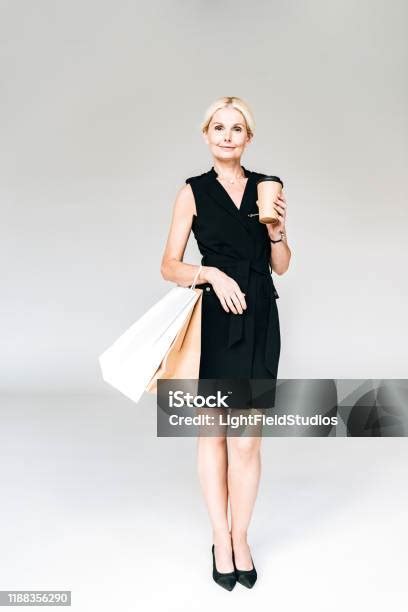 쇼핑 백과 커피와 검은 옷을 입고 우아한 금발 여자의 전체 길이보기 는 회색에 고립 갈 성년 여자에 대한 스톡 사진 및 기타 이미지 성년 여자 스튜디오 촬영 아름다움