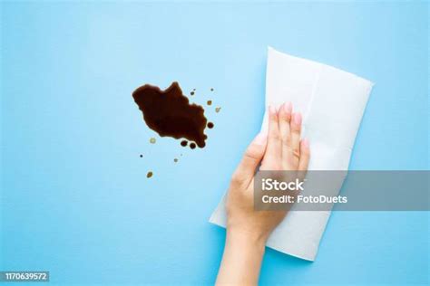 파스텔 블루 책상에서 신선한 유출 어두운 음료를 청소 하는 여자 손 커피 얼룩 이 간단한 제거 흰색 종이 냅킨 정리 닫아 맨 위 보기 때묻은에 대한 스톡 사진 및 기타