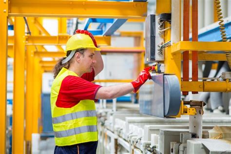 Premium Photo Worker In A Factory Operating A Factory Machine Pressing A Red Button