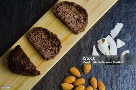 맛있는 초콜릿 빵 브라우니와 검은 색 배경에 초콜릿과 아몬드 슬라이스와 케이크 선택적 초점 맨 위 보기입니다 집에서 만든 케토 땅콩 쿠키 케토제닉 디저트 케토 다이어트