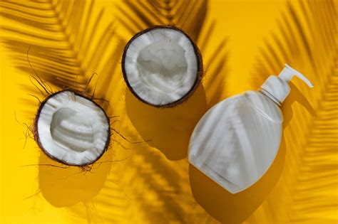 미니멀 한 아름다움 은 여전히 생활 다진 코코넛과 흰색 크림 병 두 병이 노란 배경에 야자수 잎의 그림자가 드리워져 있습니다 크리에이티브 패션 컨셉 맨 위 보기 건강한 생활