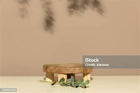 제품 프리젠 테이션을위한 빈 둥근 나무 연단과 유칼립투스는 화장품 모형을위한 베이지 색 배경에 잎 도시를 벗어난 장면에 대한