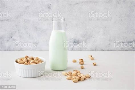 피스타치오 옆의 회색 테이블에 병에 담긴 피스타치오 우유 식물성 우유 채식주의자를 위한 견과류 우유 0명에 대한 스톡 사진 및 기타 이미지 Istock