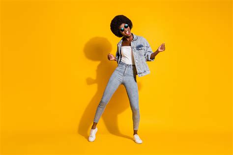 반짝이는 사랑스러운 젊은 아가씨의 전체 길이 사진 캐주얼 데님 의상을 입고 미소 짓는 춤 고립 된 노란색 배경 매우 기쁜에 대한