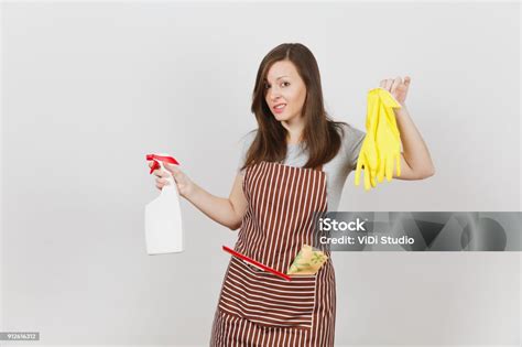 슬픈 영 스트라이프 앞치마 흰색 배경에 고립 된 포켓 고무 롤러 걸 레 청소와 피곤된 주부 화가 여자는 청소기 액체 냄새 노란색 장갑 스프레이 병을 보유 하고있다 병 복사