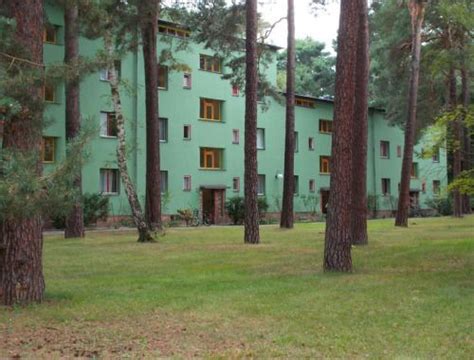 An Apartment Building Surrounded By Trees And Grass