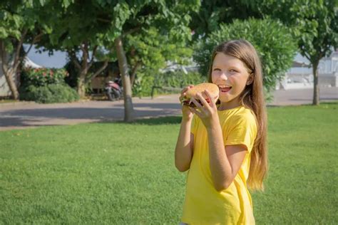 Mädchen Isst Einen Hamburger Stockfotos Lizenzfreie Mädchen Isst Einen