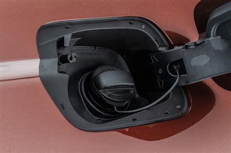 연료 주입구 도어가 열린 자동차 외부 가솔린 또는 디젤 연료를 탱크에 채우기 위해 자동차의 연료 탱크 캡을 열었습니다 차량의 연료 탱크 도어가 열려 있고 탱크 캡이 닫혀