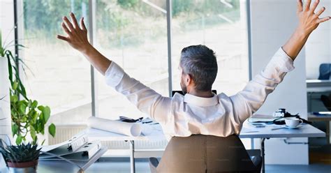 그의 사무실에서 잘 생긴 젊은 사업가 책상에 앉아 팔을 뻗는다 후면도 사진 Unsplash의 개념 이미지